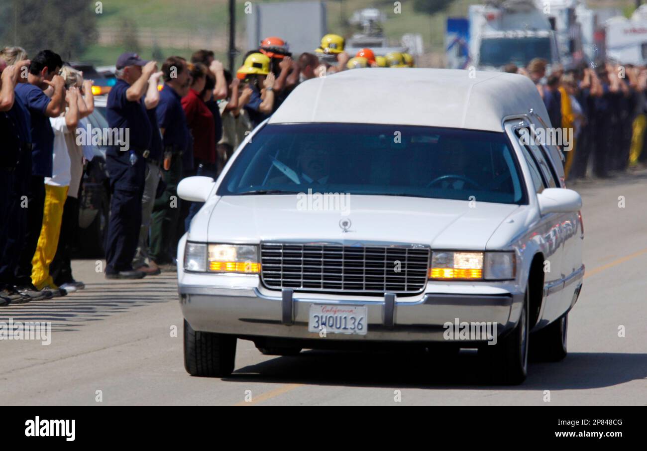 Firefighters and law enforcement officials line up at the Station fire ...