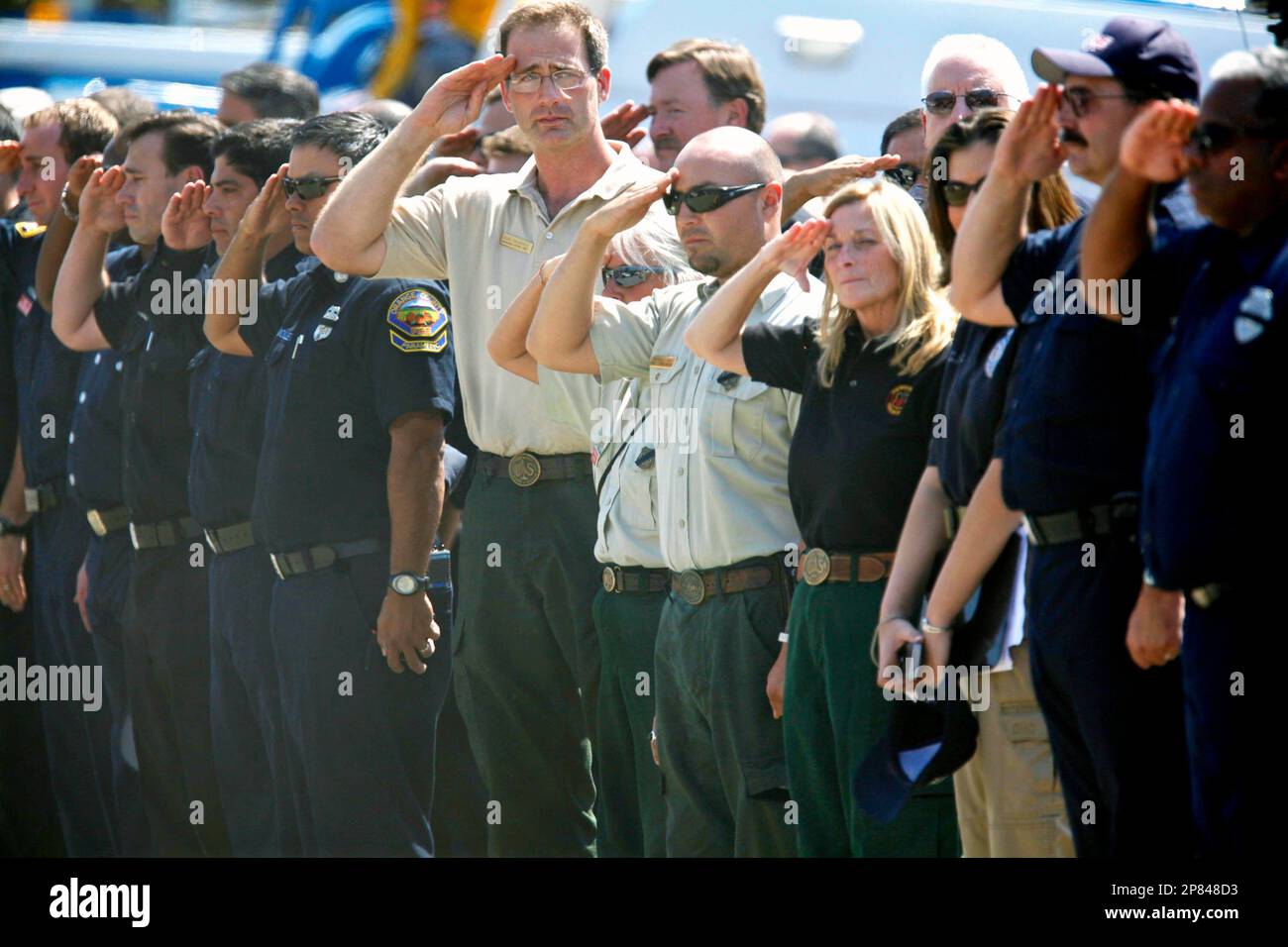 Firefighters, U.S. Forest Service and law enforcement officials line up ...