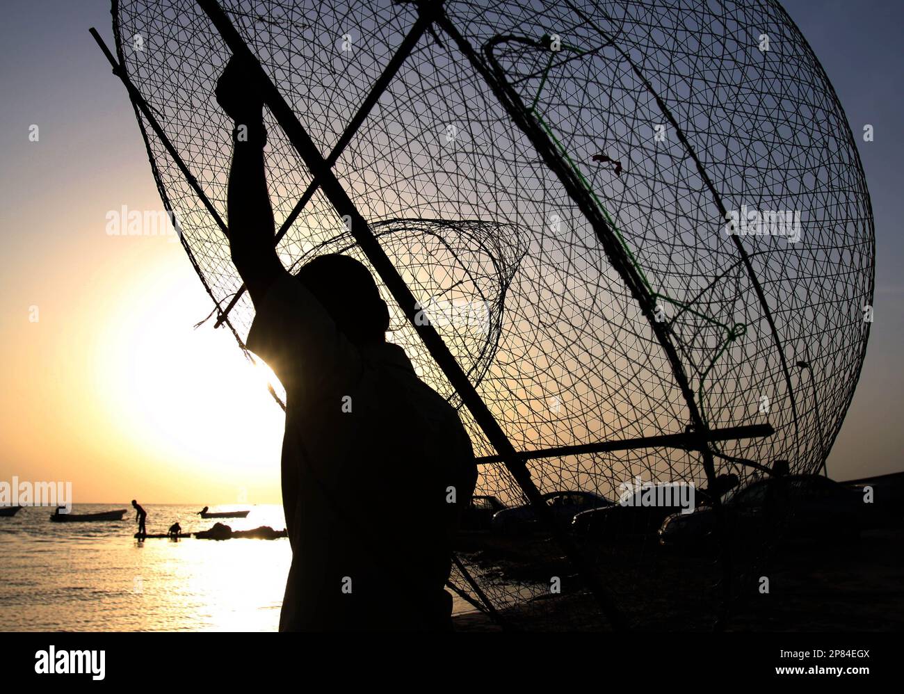 A fisherman carries his net to the seashore at dusk Wednesday, Sept. 2 ...