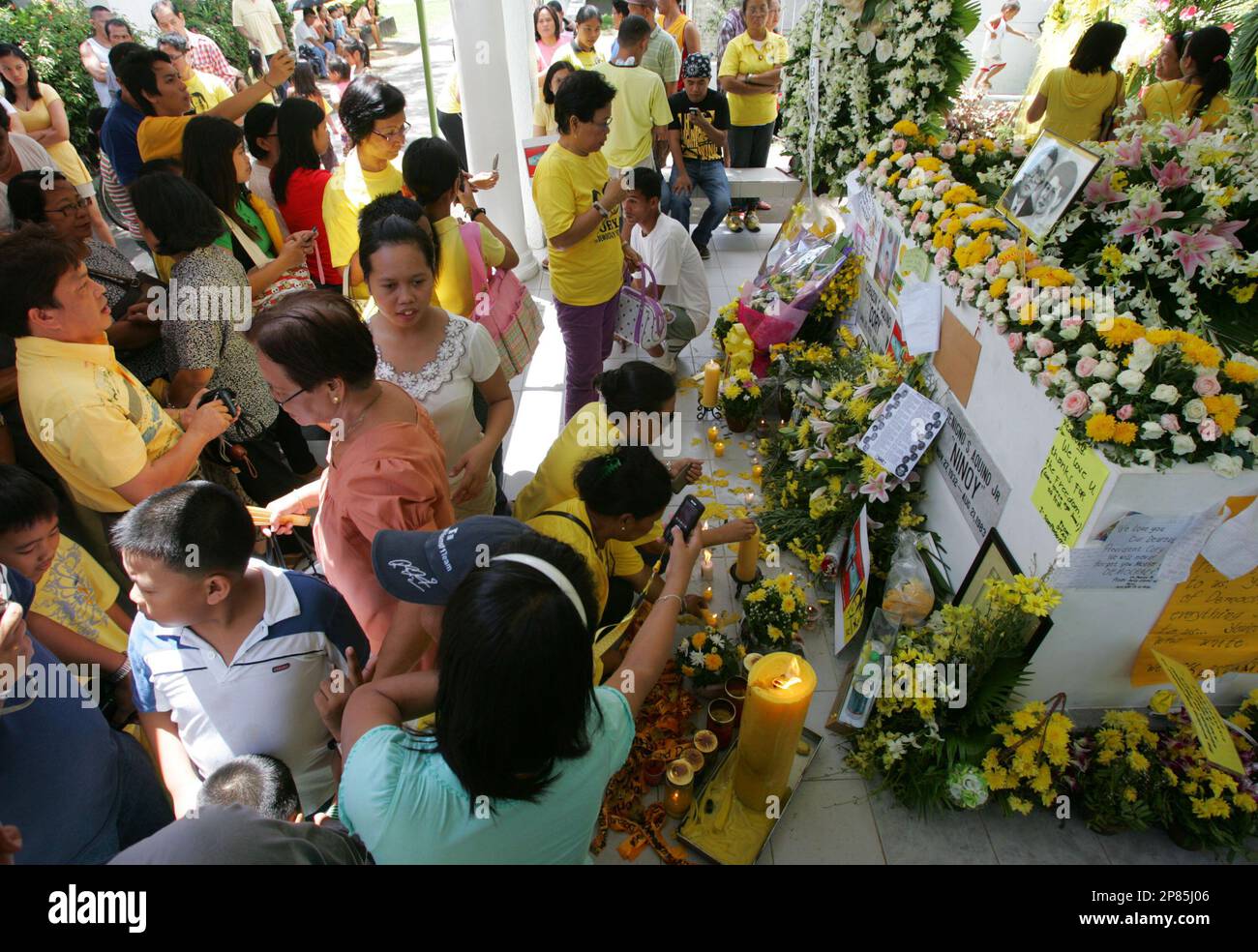 A crowd of people gather at the tomb of the late President Corazon ...