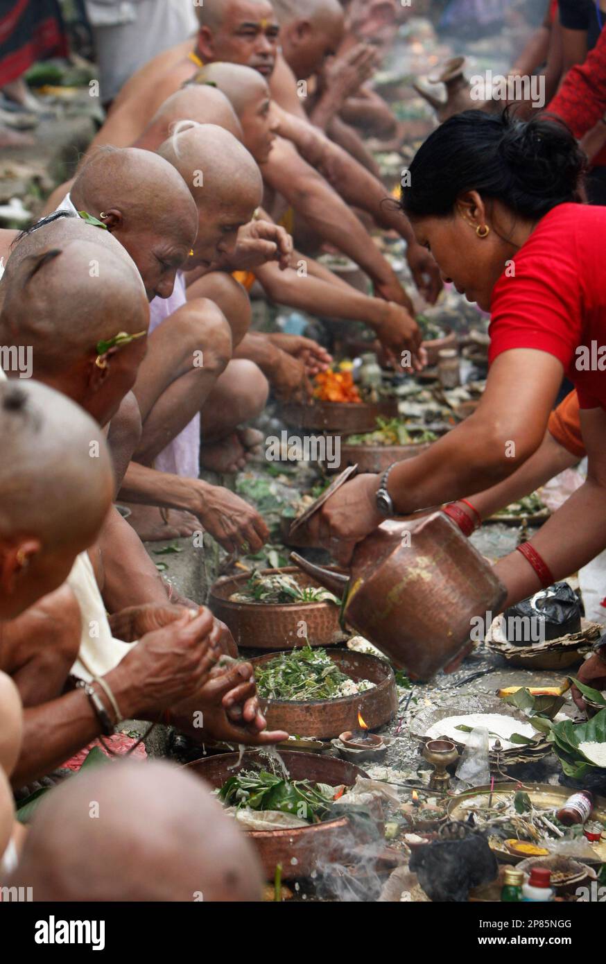 Hindu devotees with shaven heads perform rituals during "Gokarna Aunsi ...