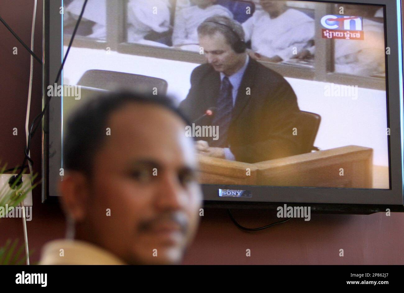 A Cambodian man watches television at a restaurant in Phnom Penh ...