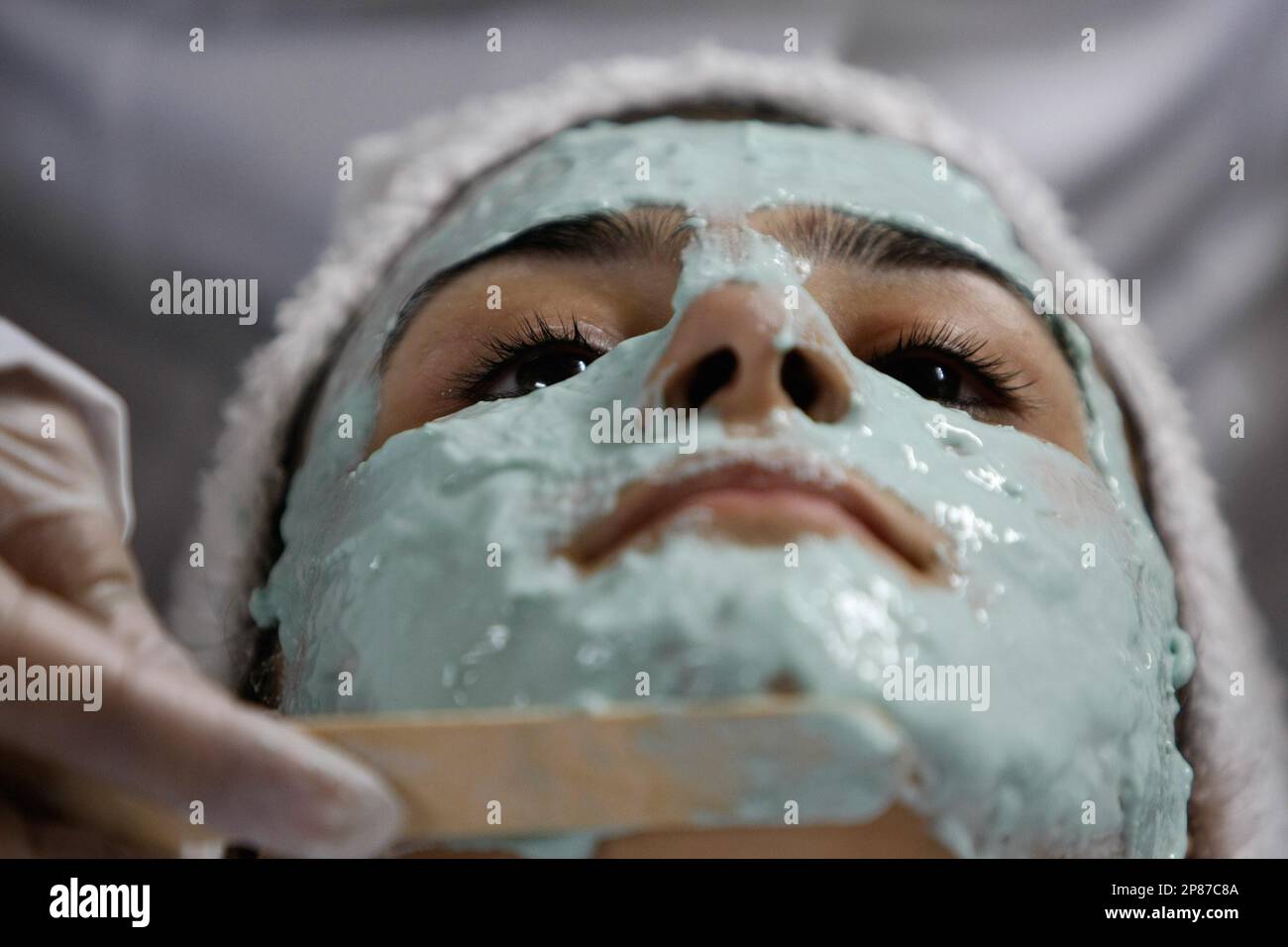 A young woman has her face treated with lightening creams by a doctor ...