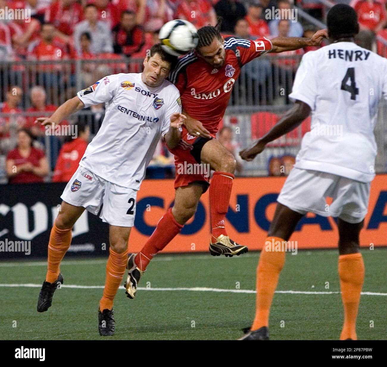 Toronto FC's Dwayne DeRosario, center, gets between Puerto Rico Islanders defenders Scott Jones ...
