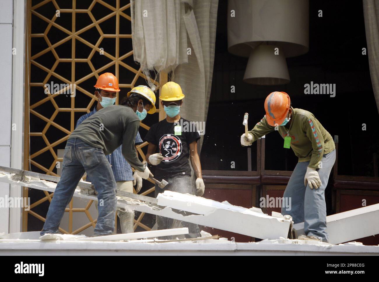 Indonesian workers destroy debris to remove them from a balcony of the ...