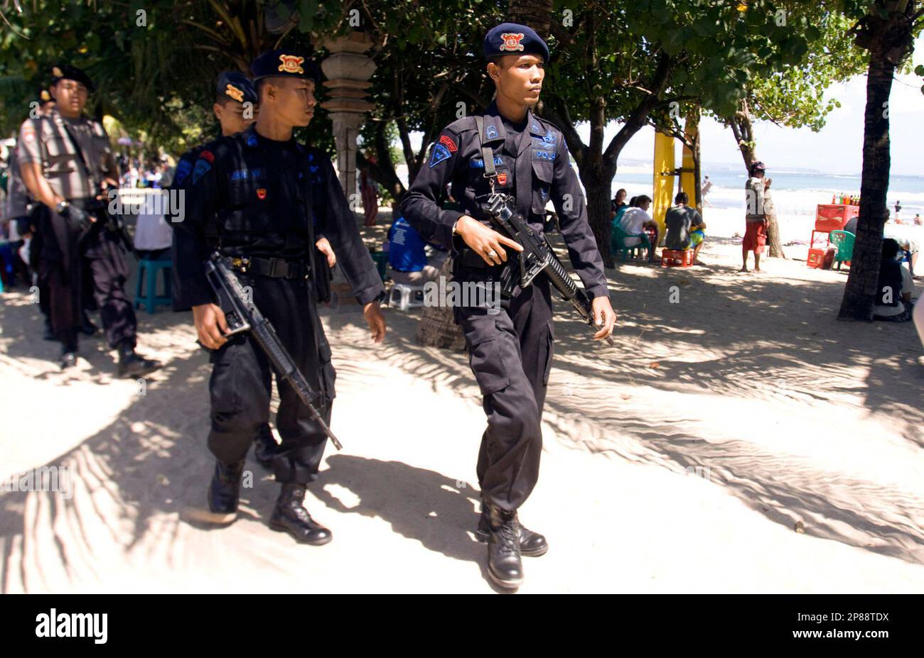 Indonesian police officers patrol along Kuta beach in Bali, Indonesia ...
