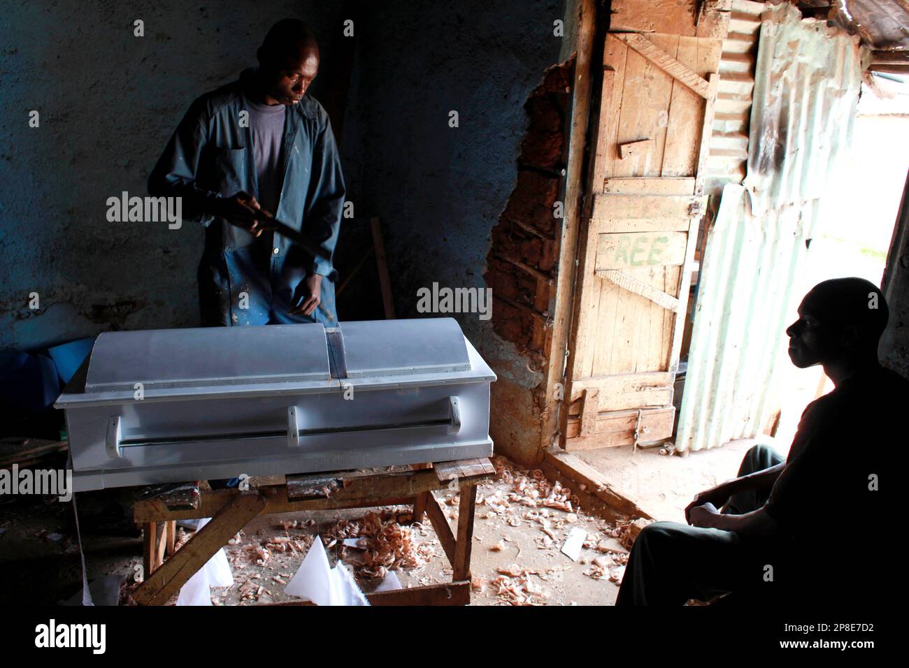 Carpenters make a child's coffin, inside their shop in the Kibera slum ...