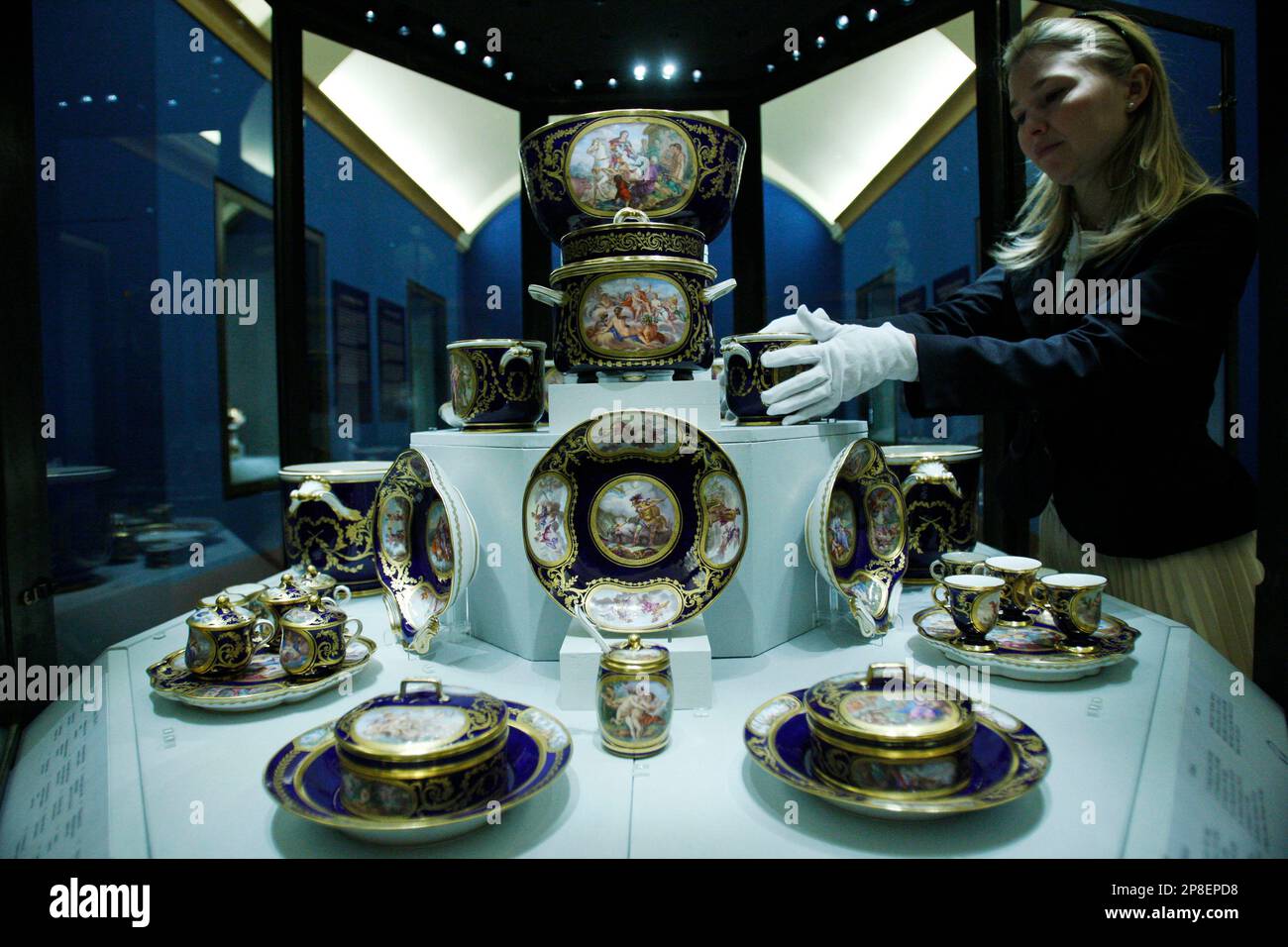 A gallery staff member poses with a dinner and dessert service set ...