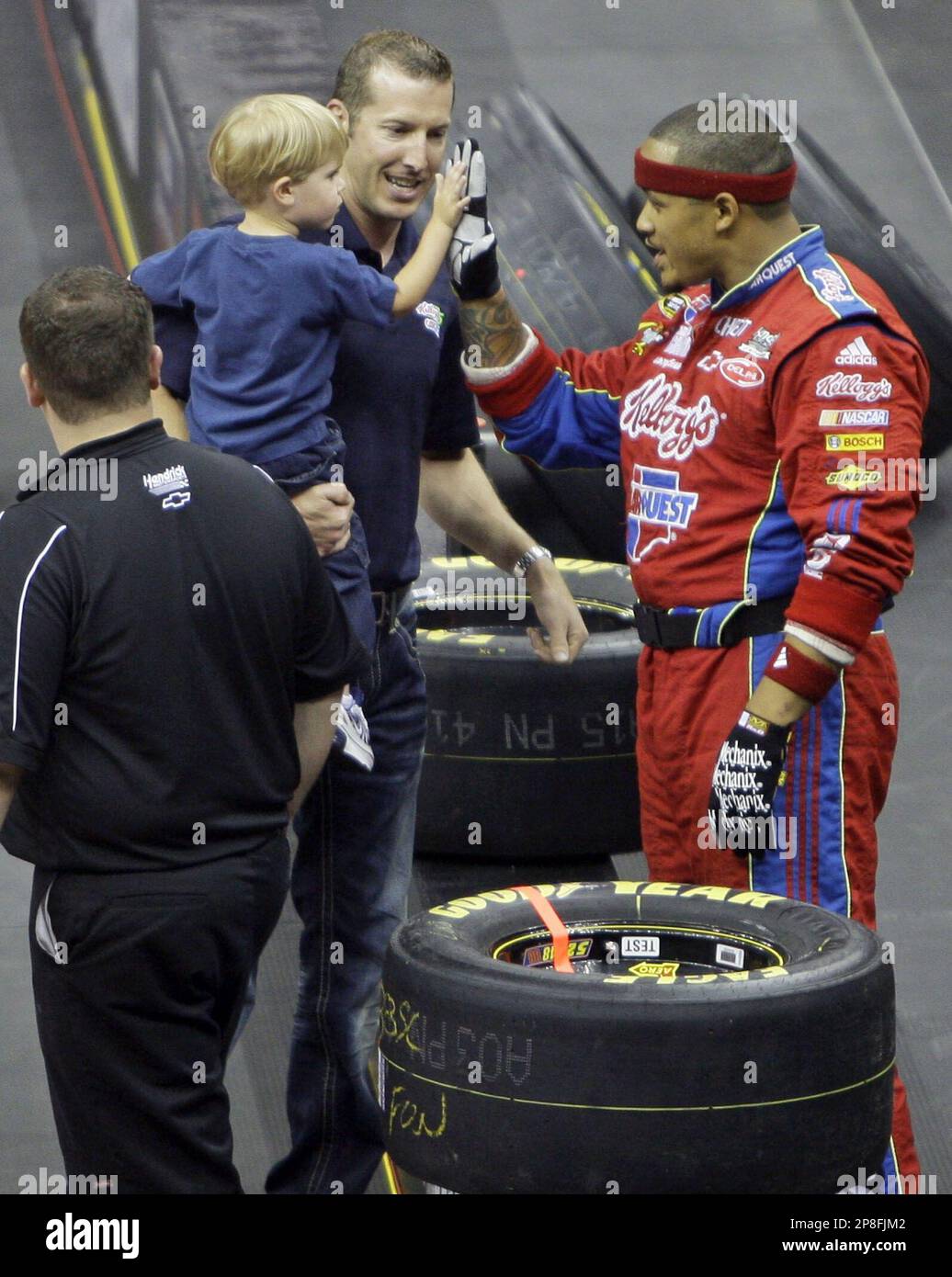 Crew chief Alan Gustafson, center, and his son, greet rear tire carrier ...
