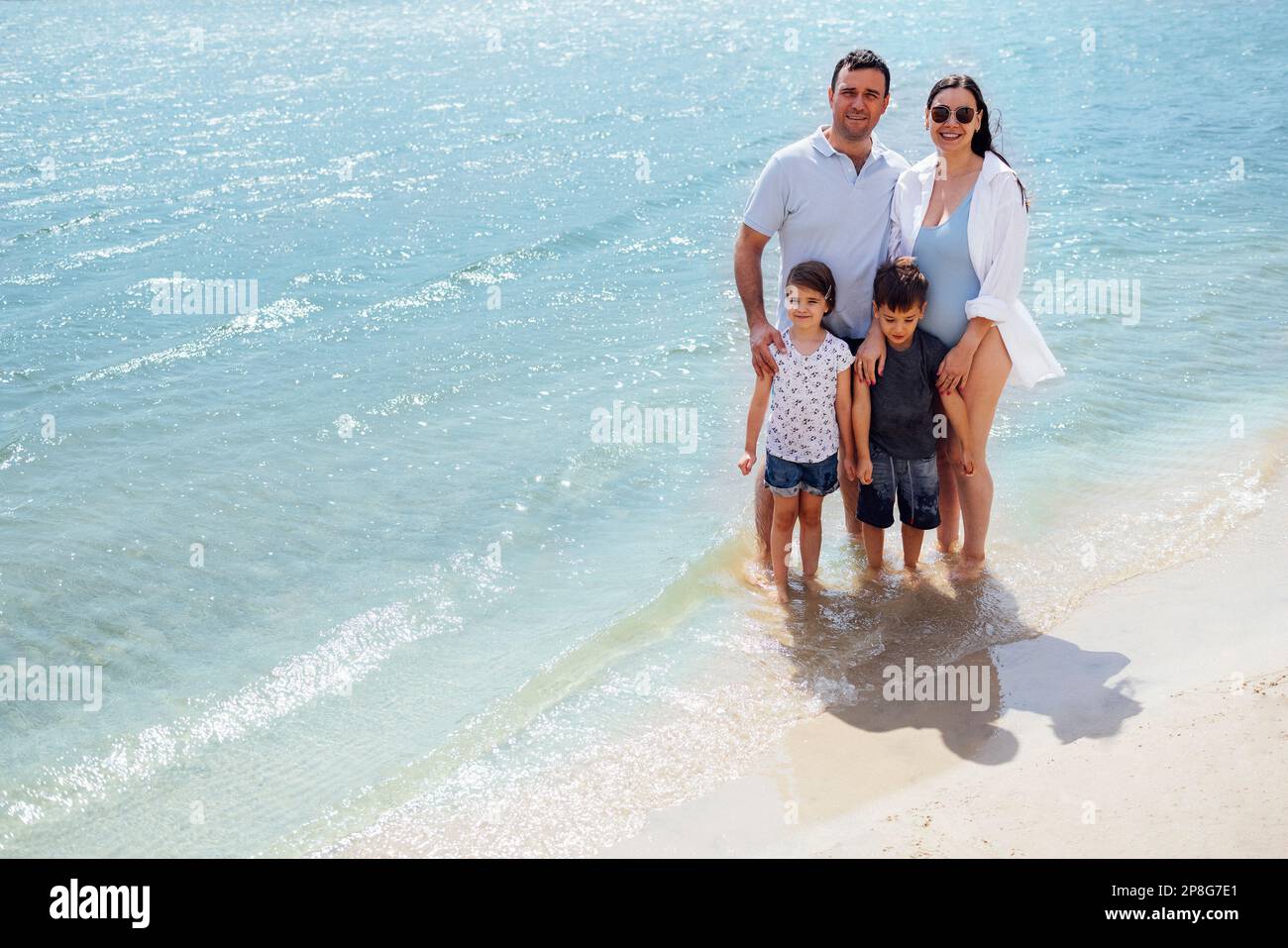 Glückliche Familie auf dem See oder Fluss. Sohn und Tochter Rennen auf dem Wasser und spritzen ...