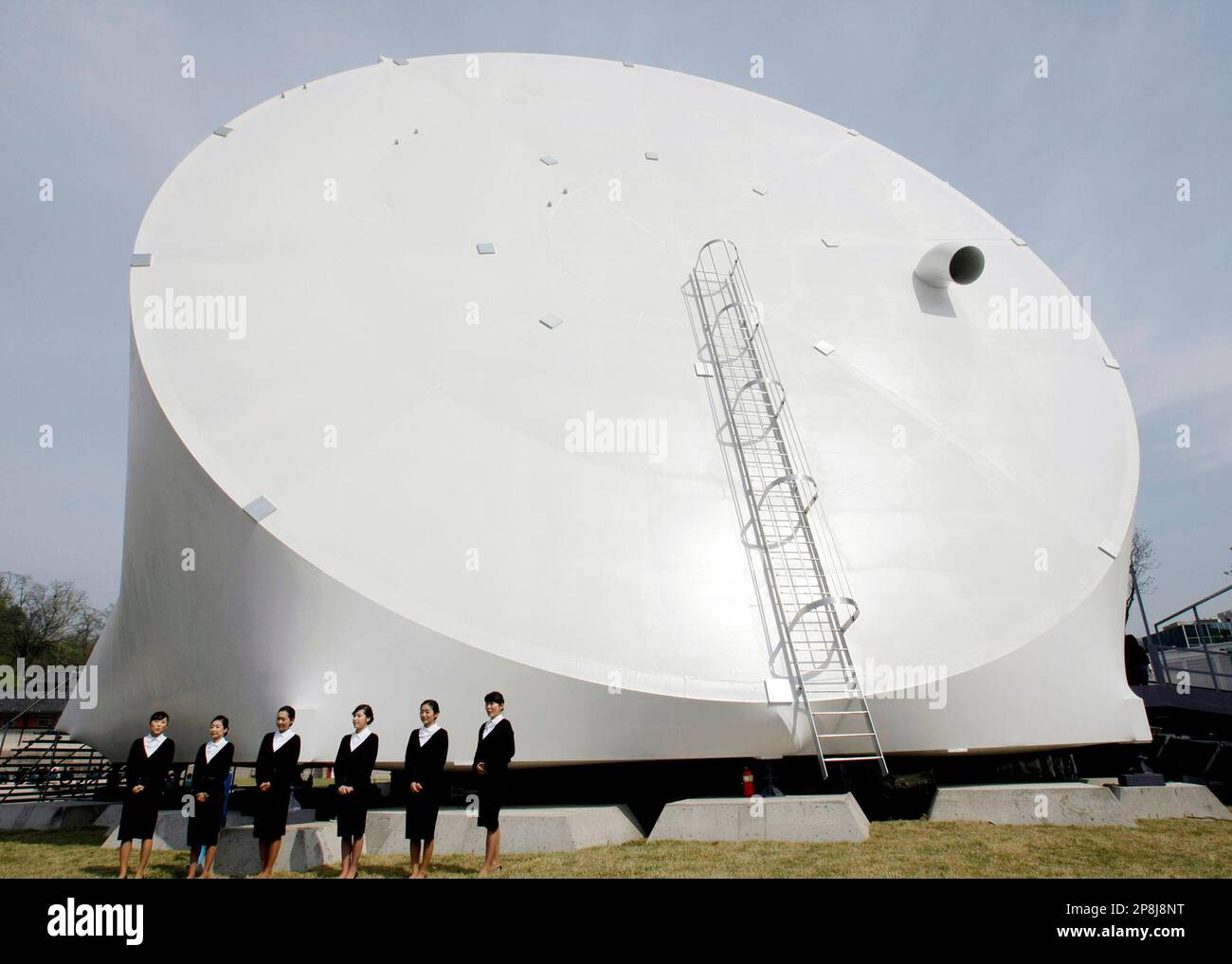 South Korean women stand next to a project structure, called Prada ...