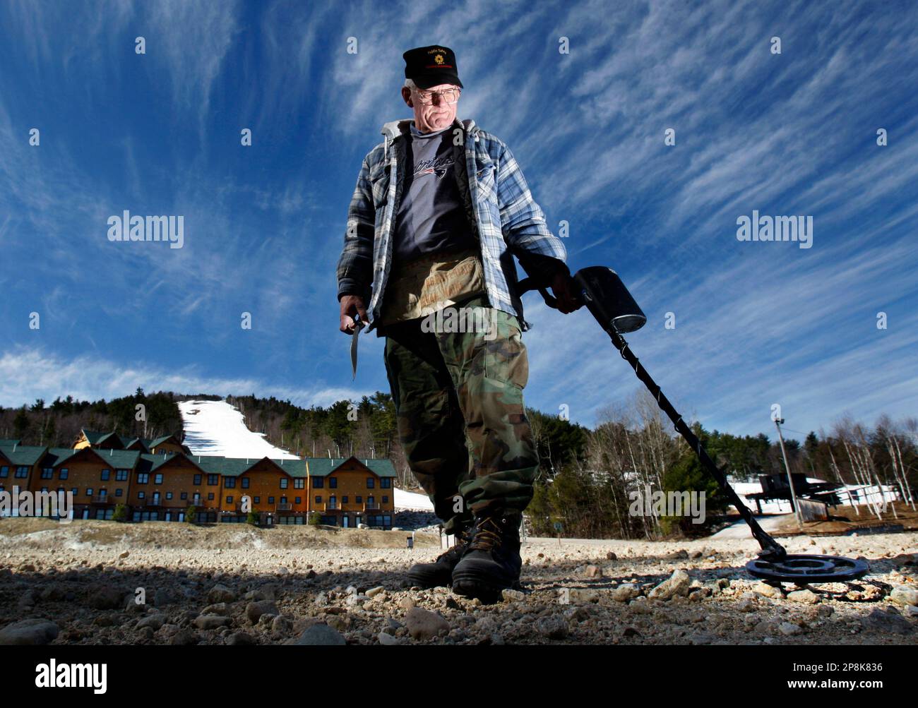 Fred Harlow sweeps his metal detector over the gravel parking lot in ...