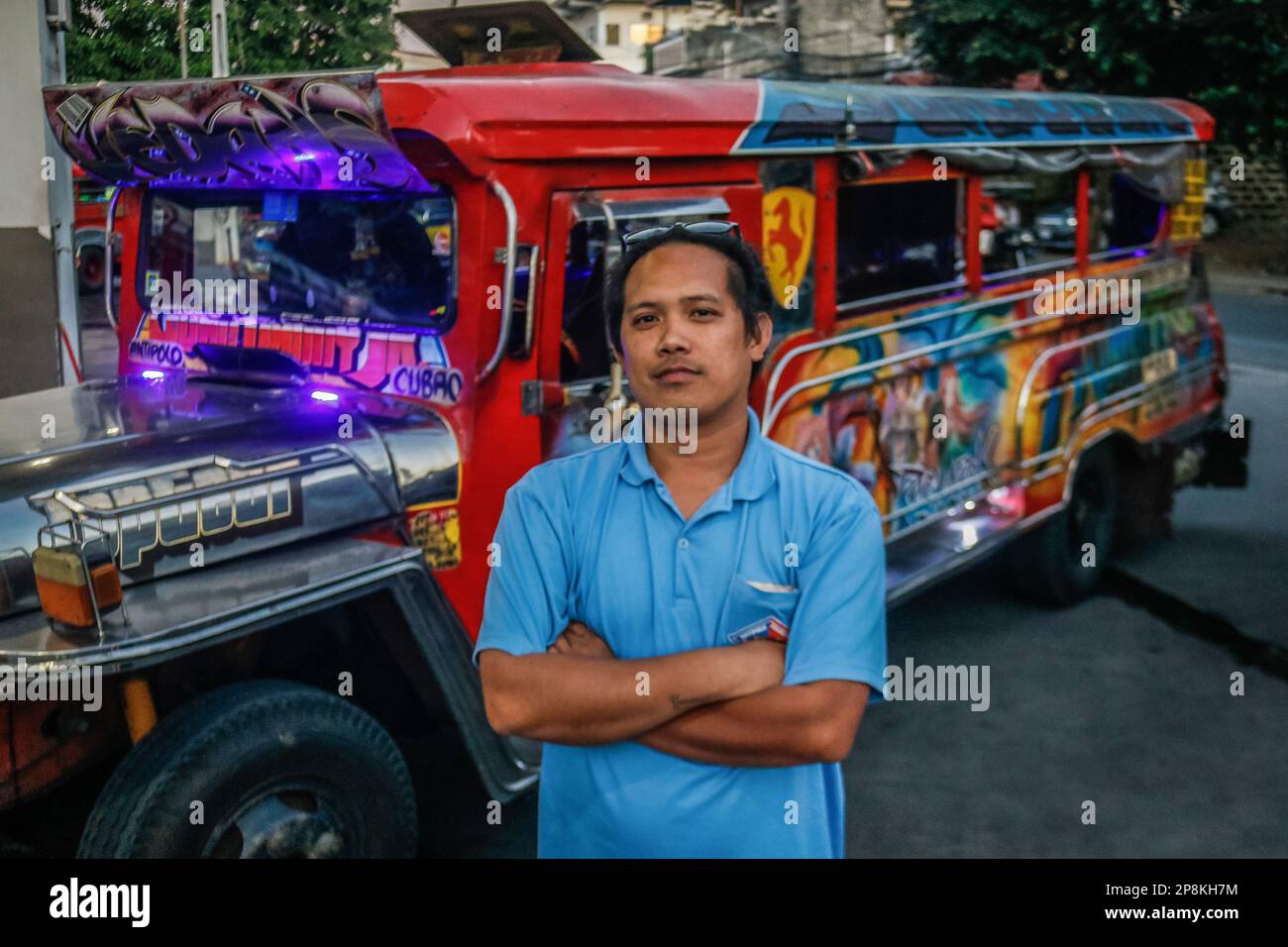 Mark steht neben seinem traditionellen Jeepney und posiert für die ...