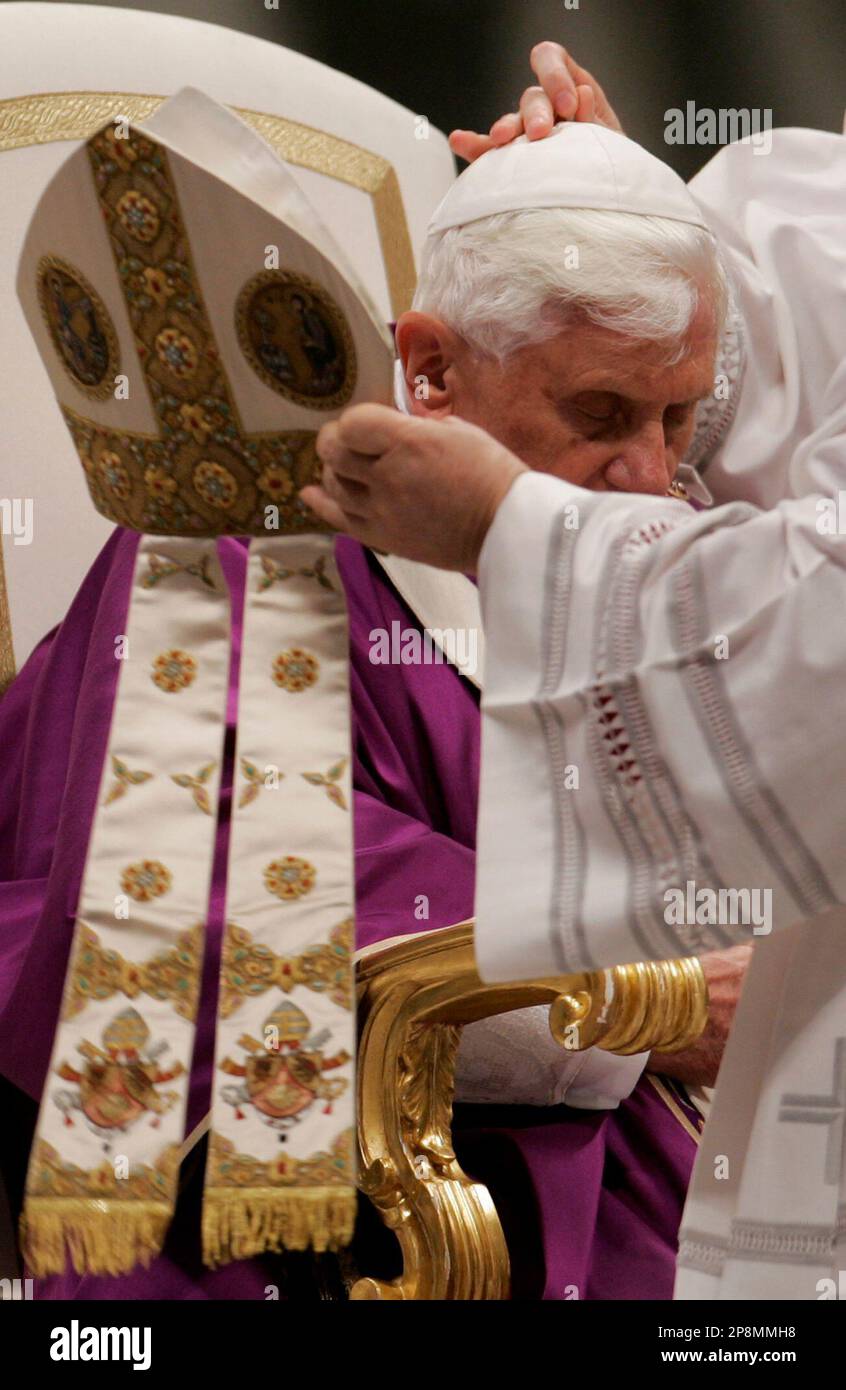 Bishop Guido Marini, partially seen, adjusts Pope Benedict XVI's skull ...