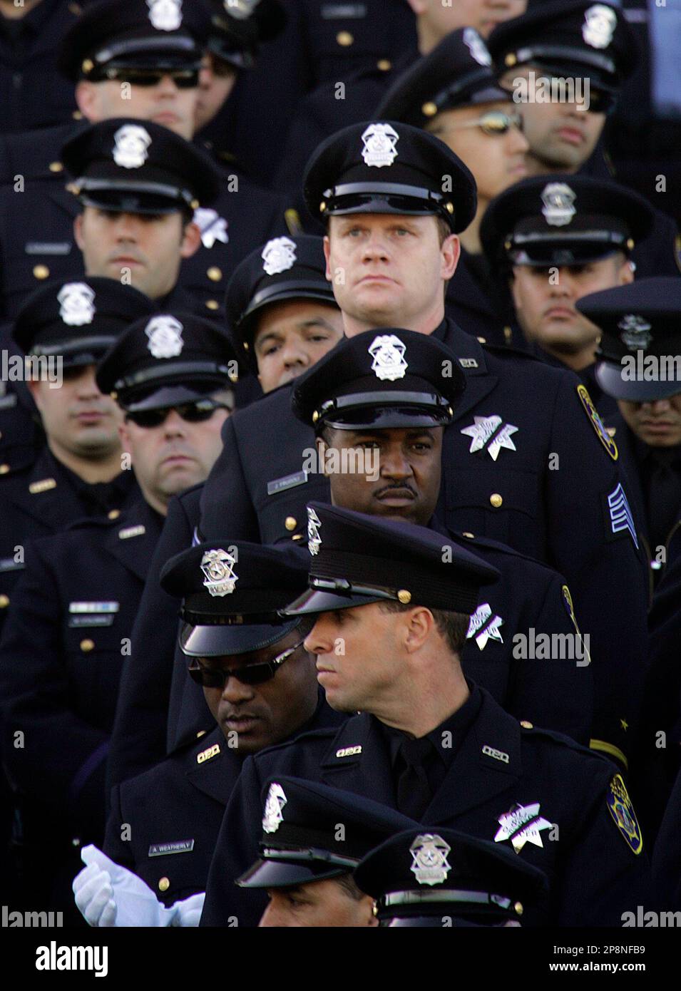 Oakland police officers await the arrival of hearses carrying fallen ...