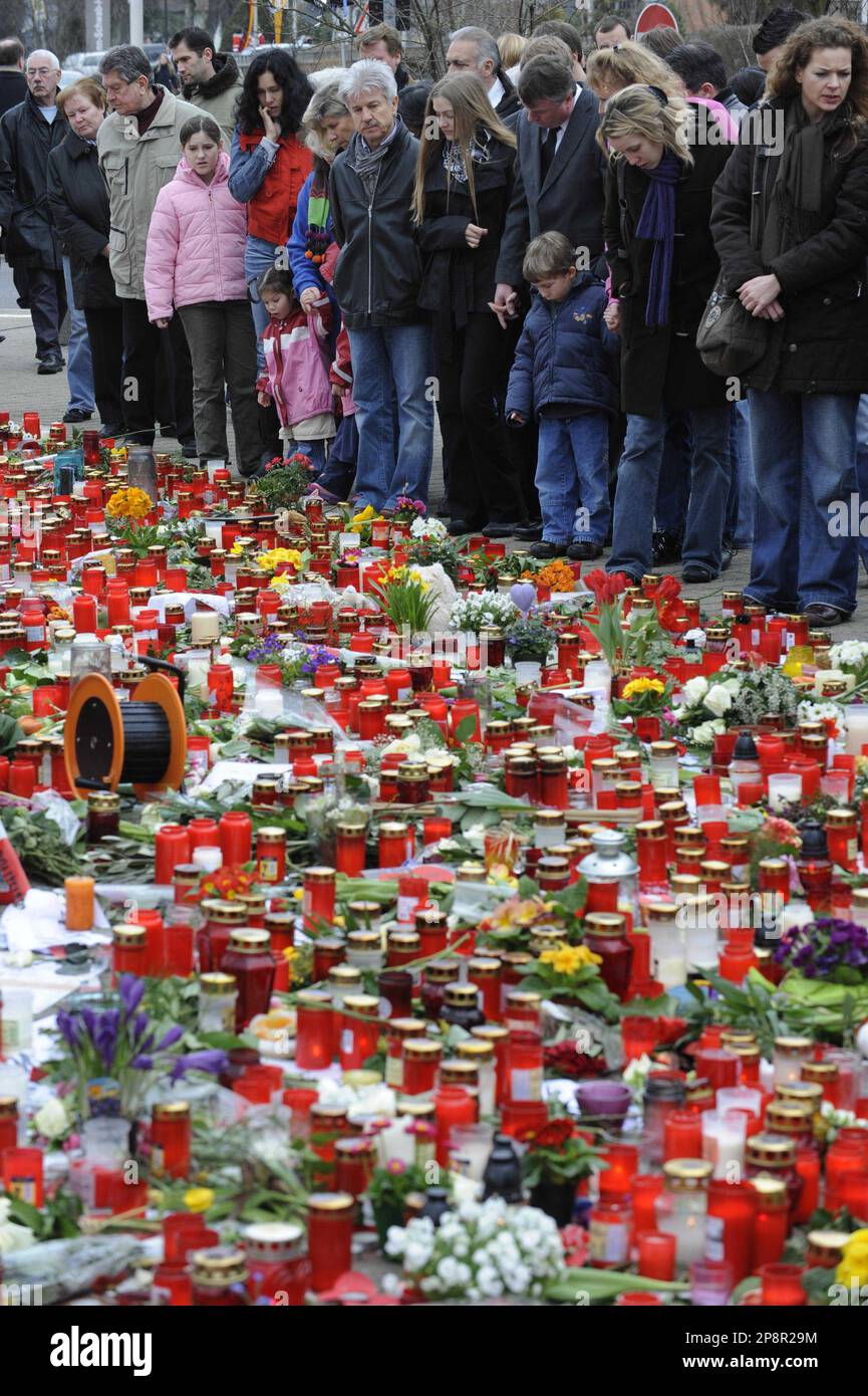 Trauernde stehen am Sonntag, 15. Maerz 2009, vor Kerzen und Blumen, die ...
