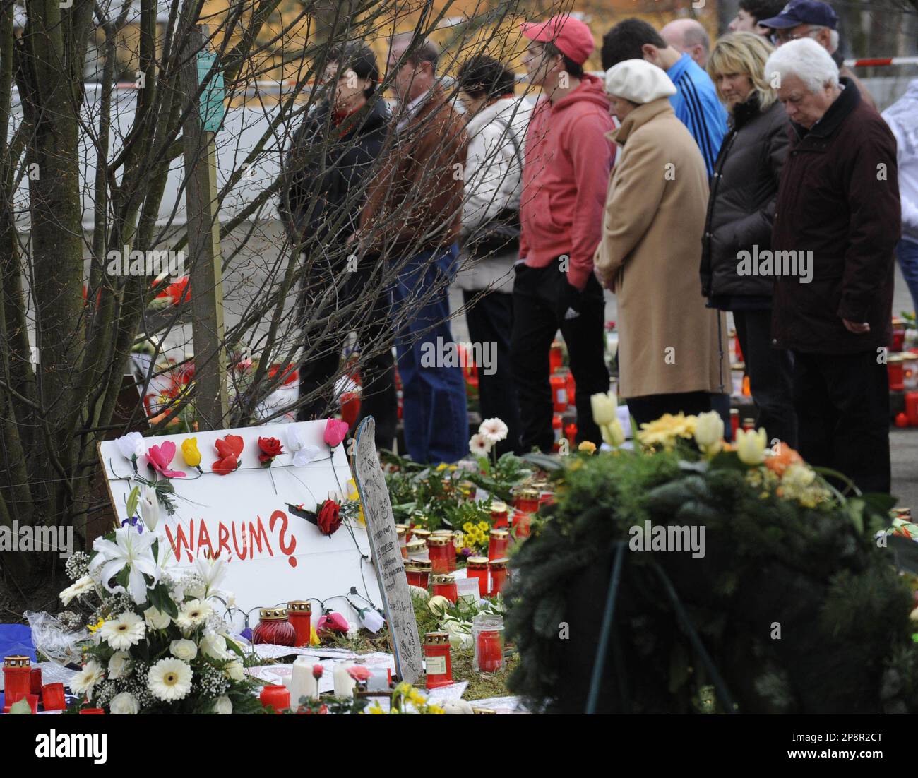 Trauernde stehen am Sonntag, 15. Maerz 2009, vor Kerzen und Blumen, die ...