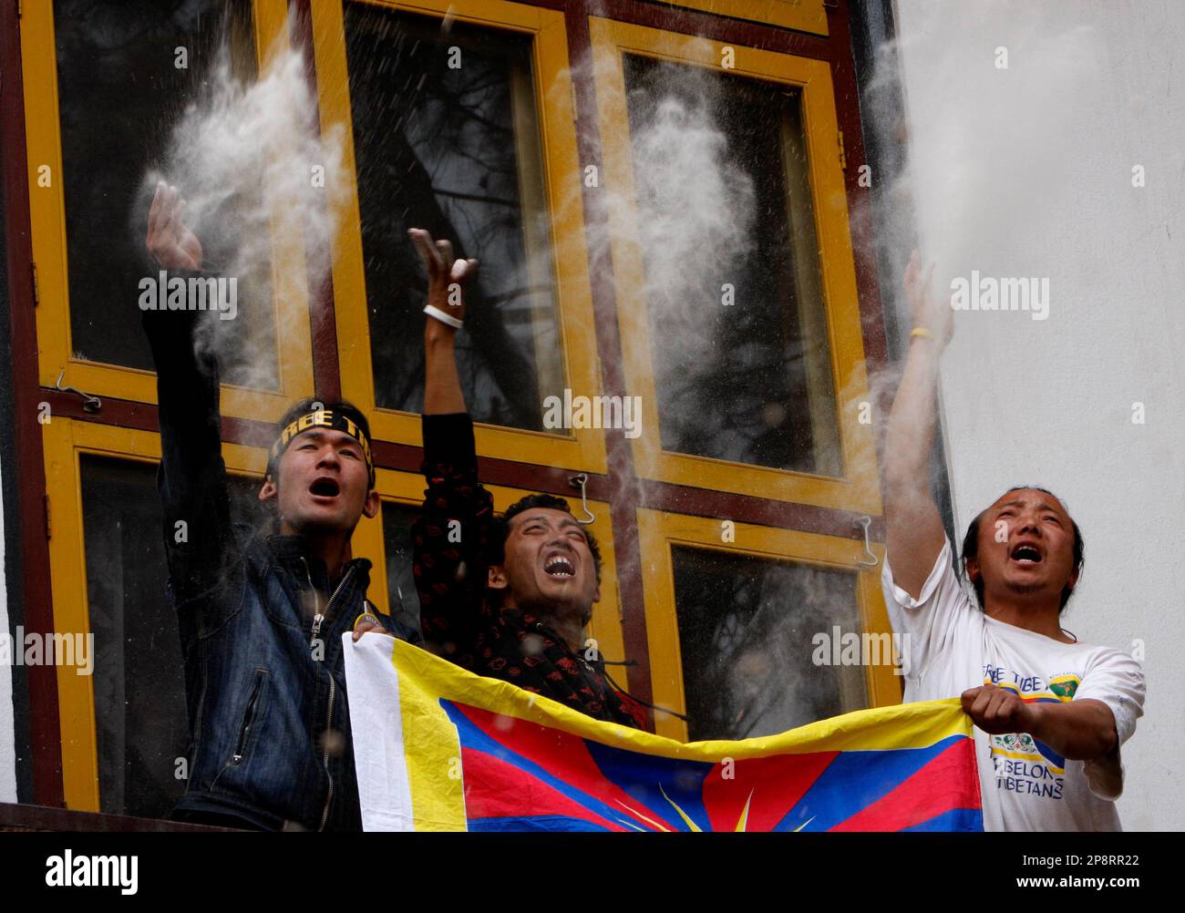 Tibetan in exile throw wheat powder during a pray session to mark 50th ...