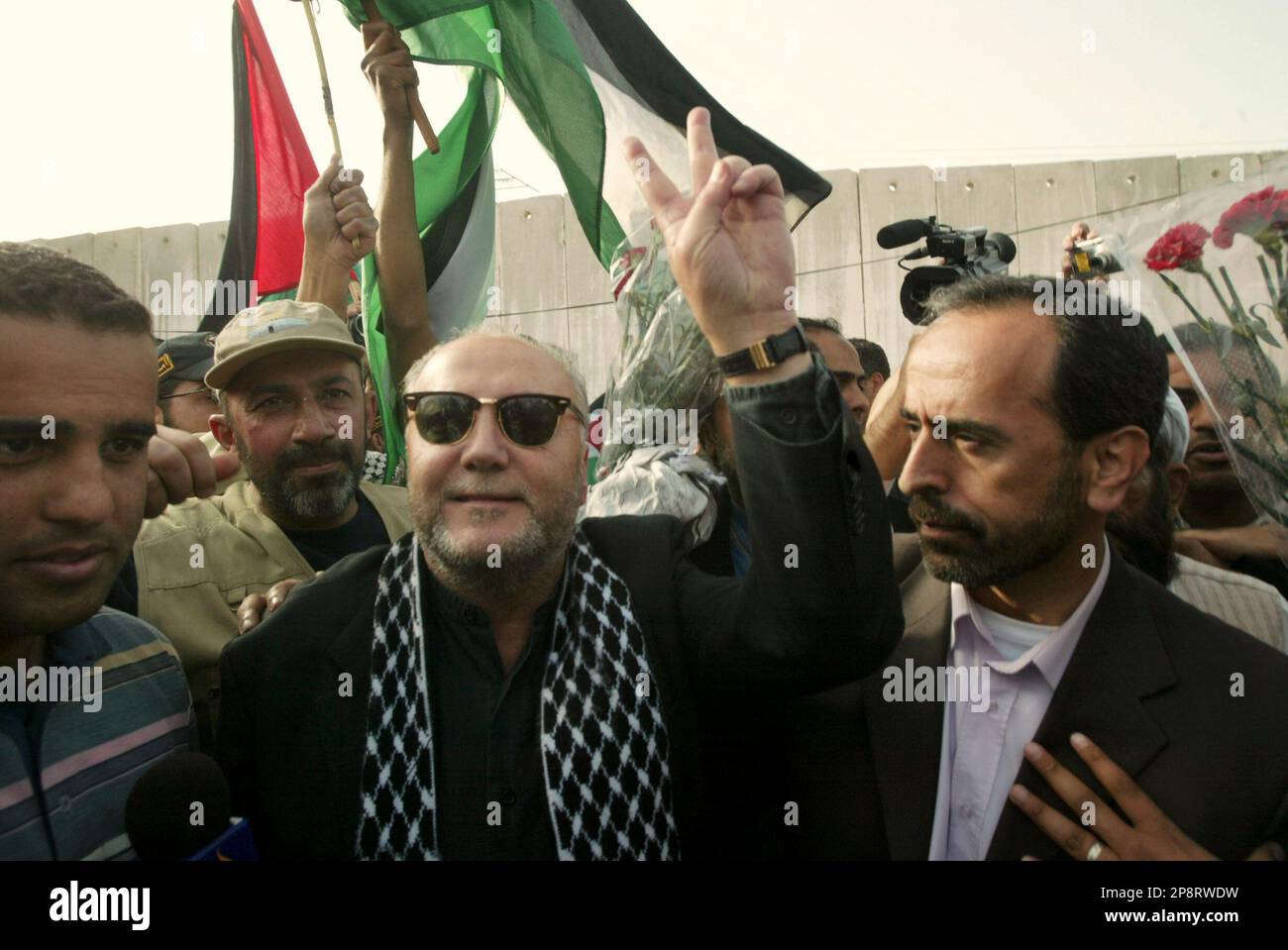 British lawmaker George Galloway, center, flashes the victory sign upon ...