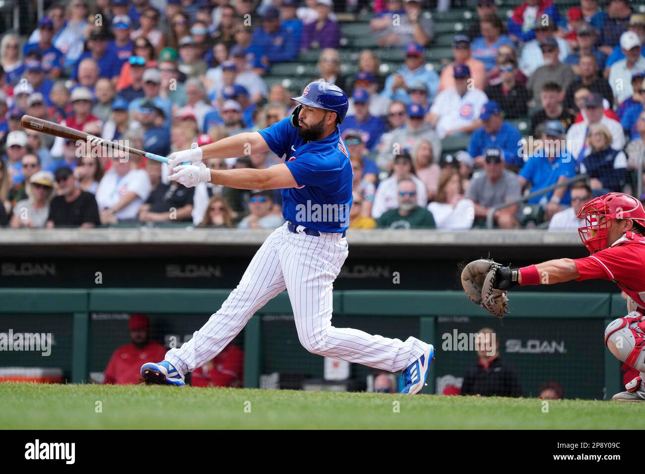 Chicago Cubs' Eric Hosmer, left, strikes out as Cincinnati Reds catcher ...
