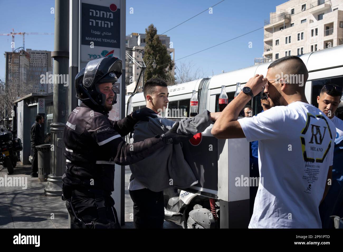A Palestinian youth is frisked by an Israeli motorcycle police officer ...