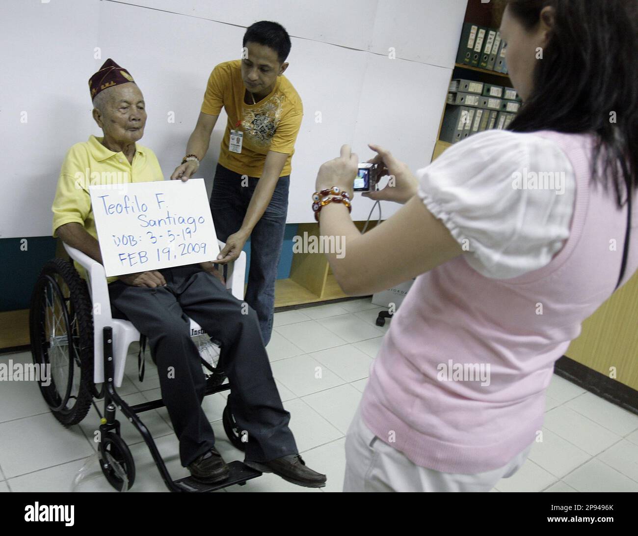 Filipino war veteran Teofilo Santiago, left, has his picture taken ...