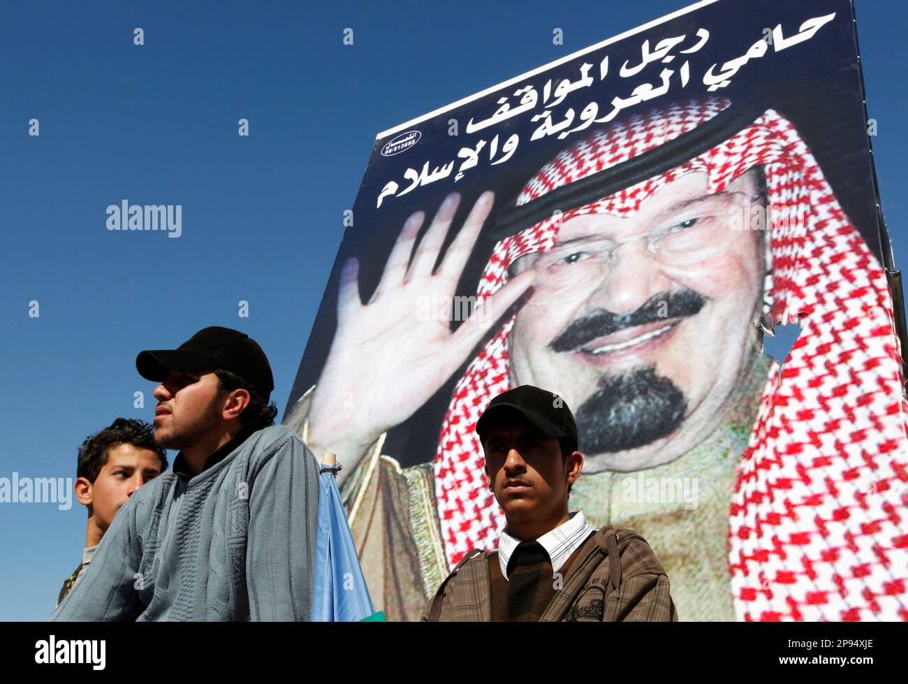 Protesters stand in front of a picture of Saudi Arabia's King Abdullah ...