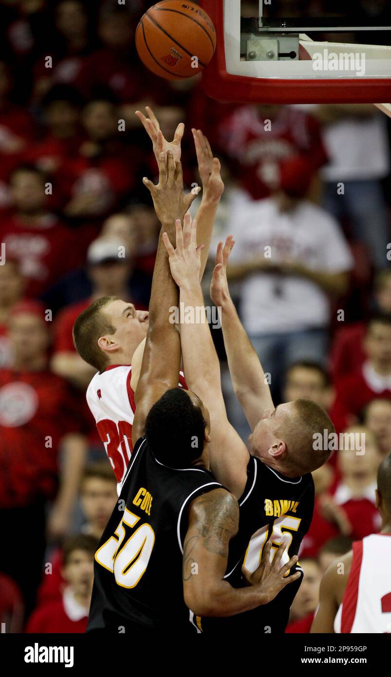 Wisconsin's Jon Leuer (30) shoots against Iowa's Jarryd Cole (50) and ...