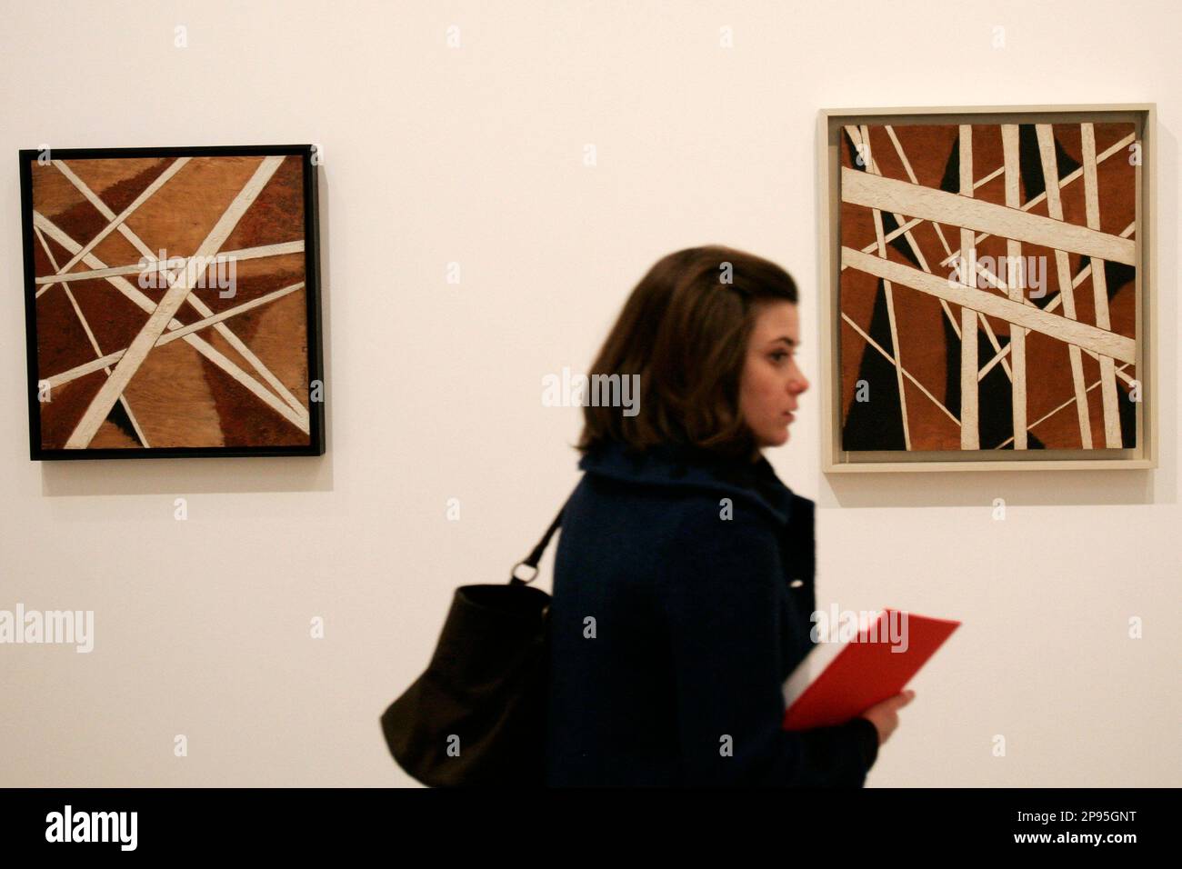 A visitor walks pass paintings 'Space-Force Construction' by Russian artist Liubov Popova on ...