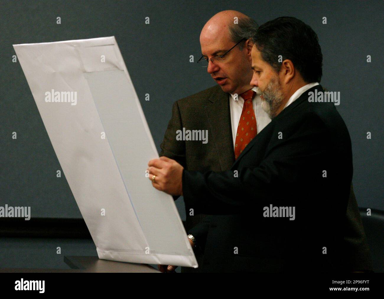 Galveston County Medical Examiner Dr. Stephen Pustilnik, left, goes ...