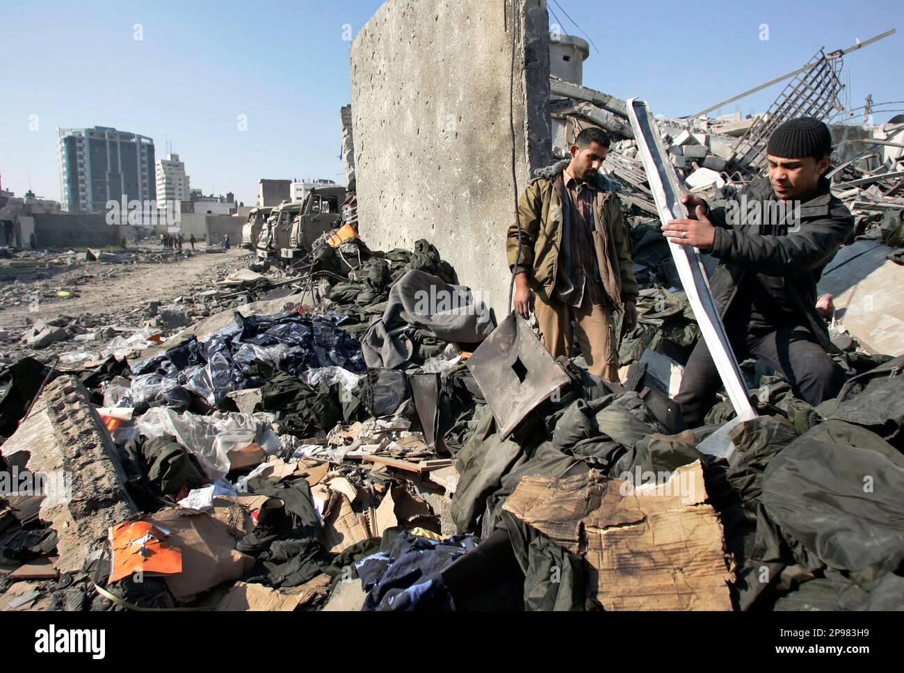 Hamas police officers try to salvage uniforms from the rubble of the ...