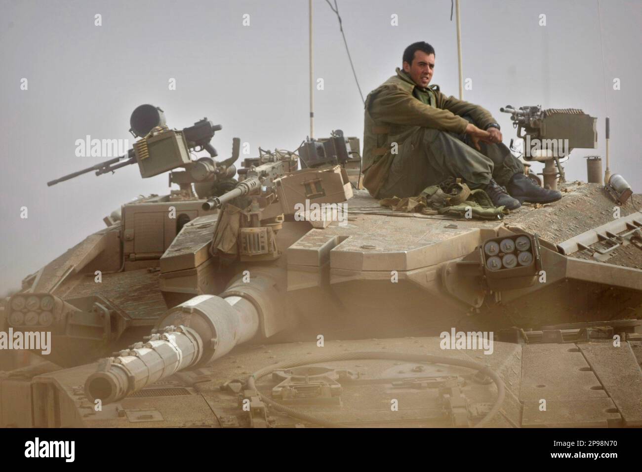 An Israeli soldier sits atop tank on the Israel-Gaza border as seen ...