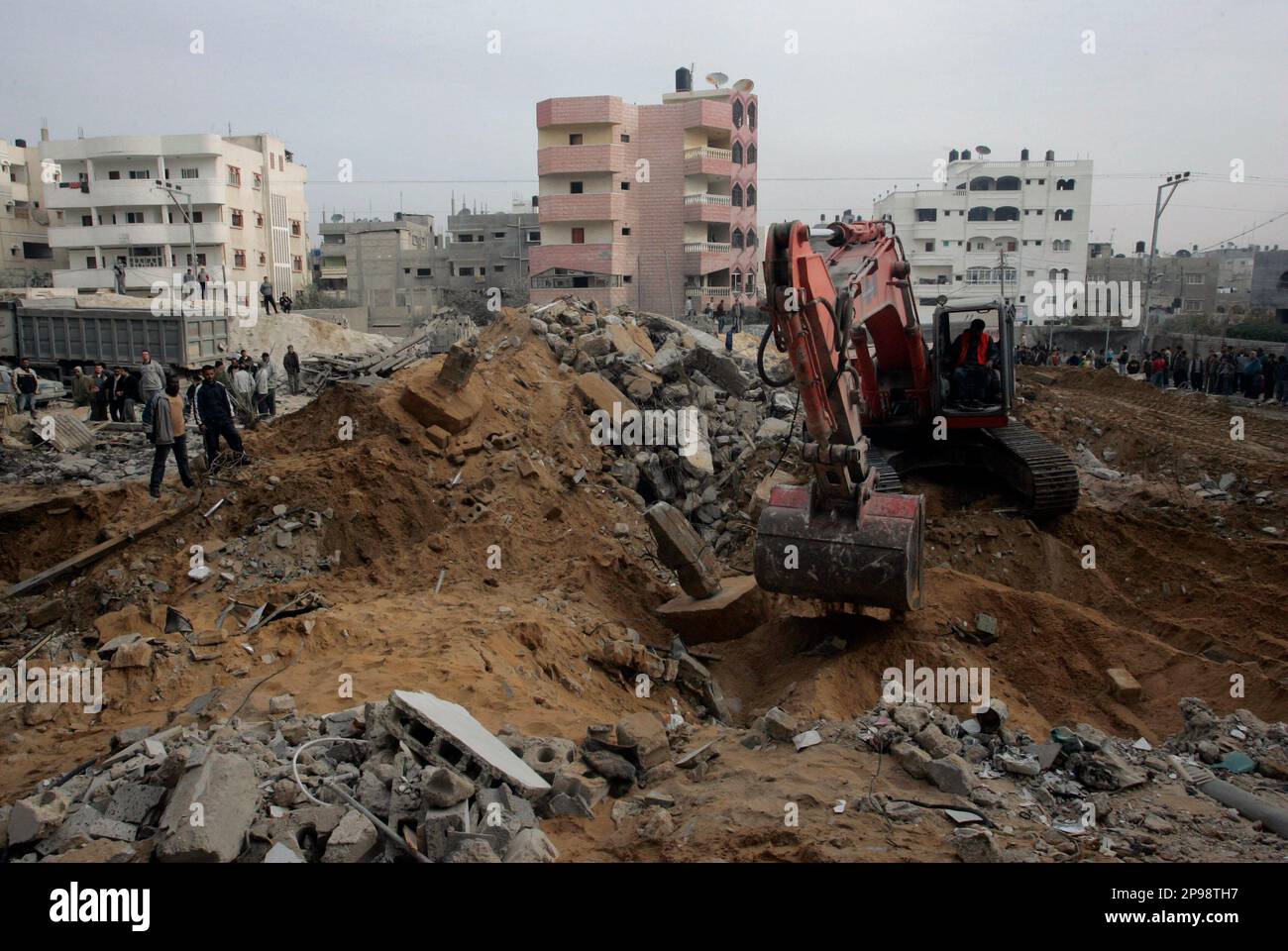 A bulldozer covers the crater caused by an Israeli strike which hit the ...