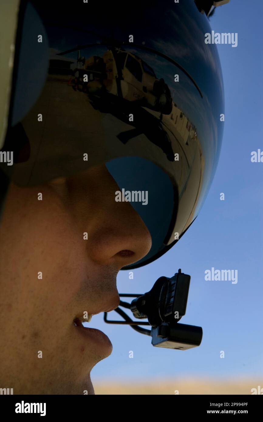 An Apache Longbow attack helicopter is reflected in the combat helmet ...