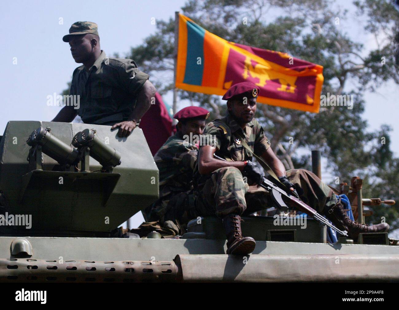 Sri Lankan army soldiers ride a battle tank as the national flag of Sri ...