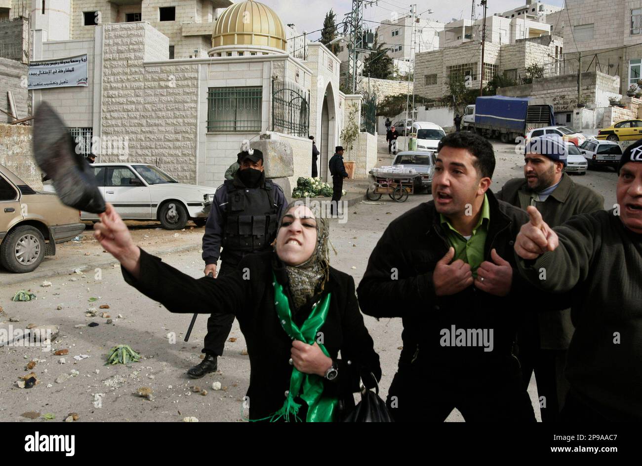 A female Palestinian Hamas supporter throws her shoe at Palestinian ...