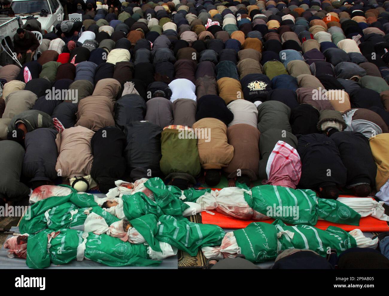 Palestinians pray next to the bodies of family members of Hamas leader ...