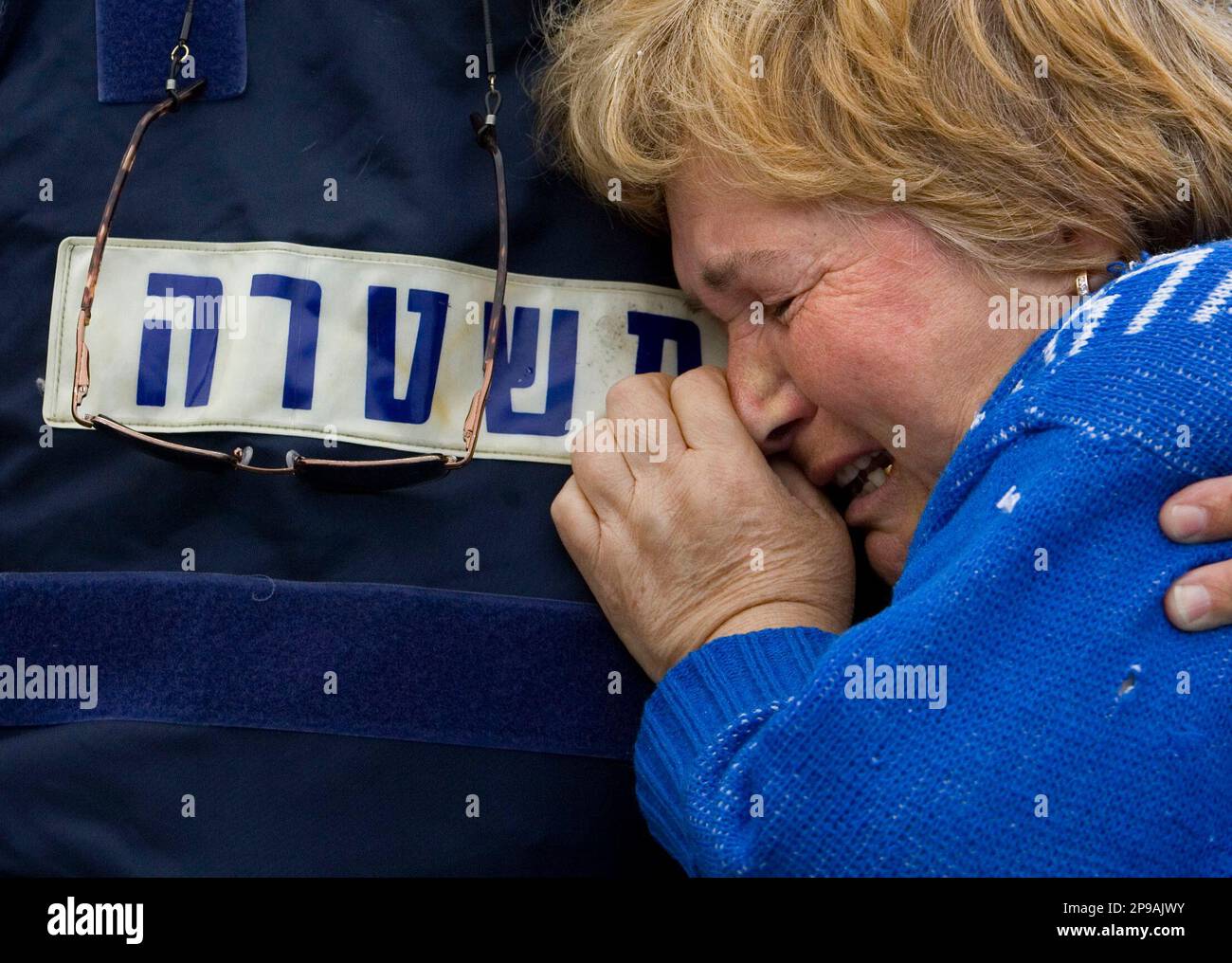 An Israeli police officer comforts a woman after a rocket fired by ...