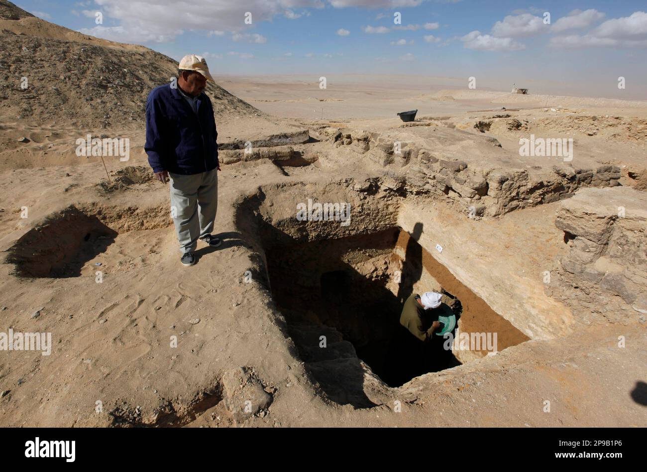 An Egyptian archaeologist and a labor worker at the excavation site of ...