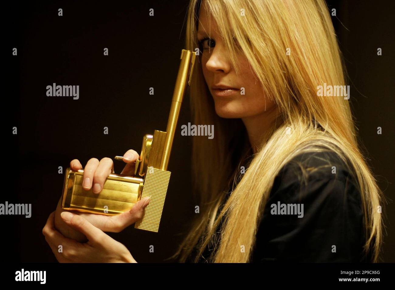 Christie's employee Sam Rowe poses for photographs with a 24 carat gold ...