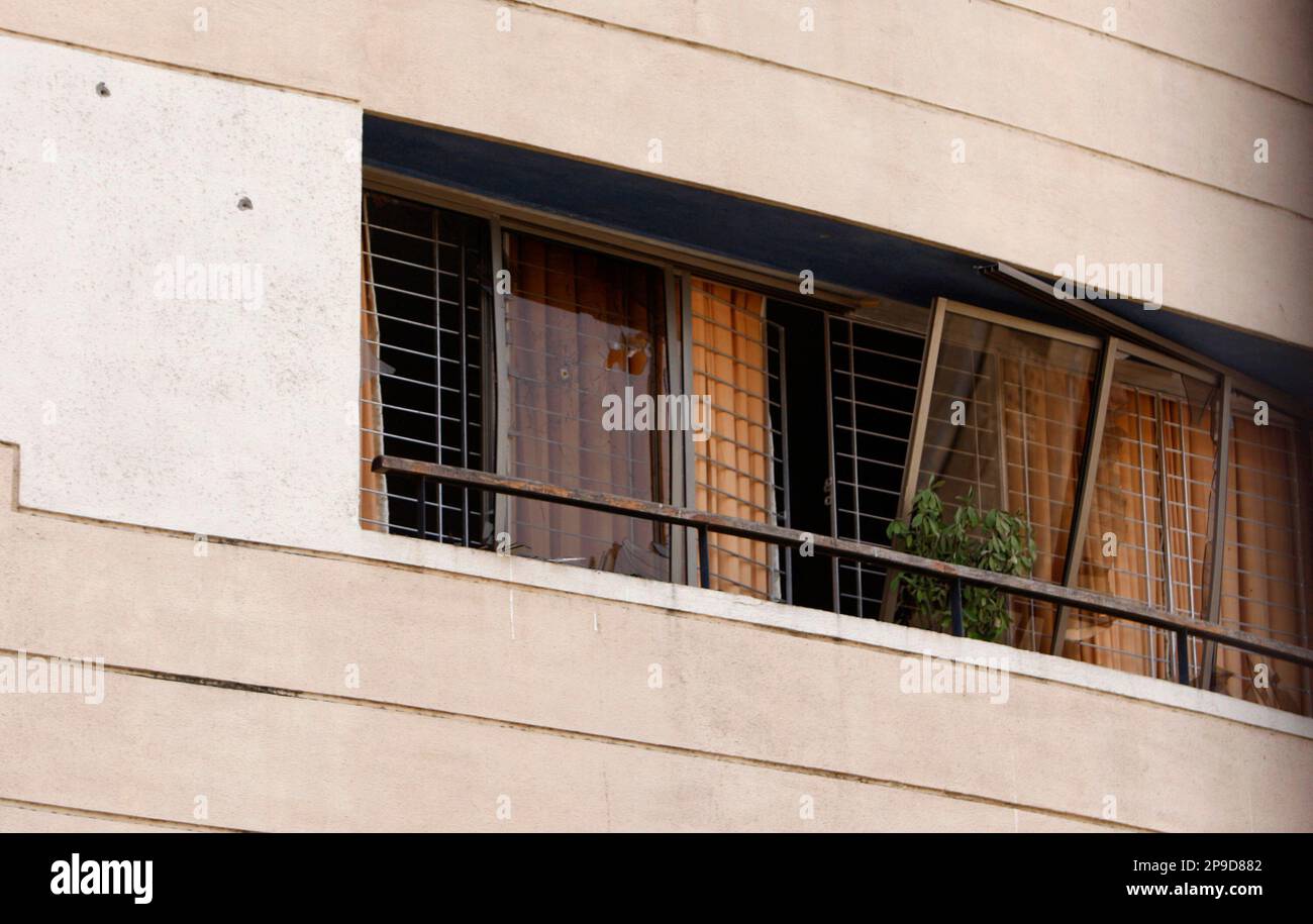 Broken windows and bullet marks are seen on the building housing a ...