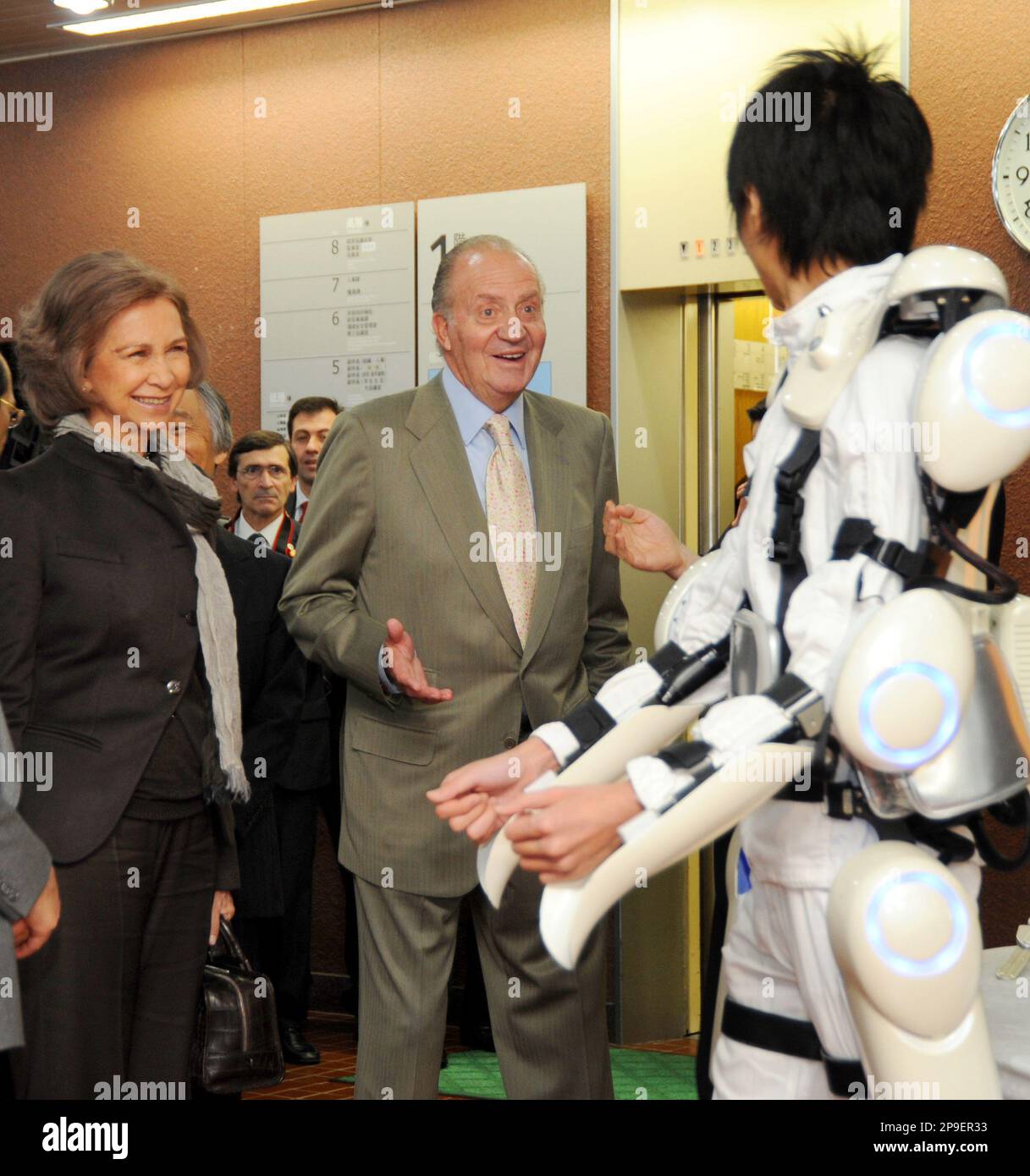 King Juan Carlos of Spain talks to Takeru Sakurai, who's wearing a HAL ...