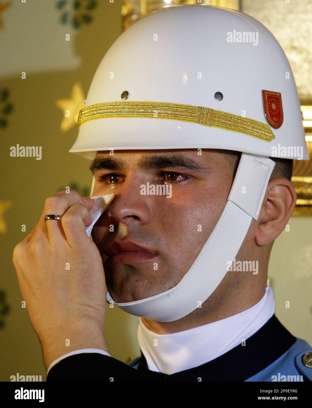 Tears are wiped from a Turkish soldier face as he stands guard next to ...