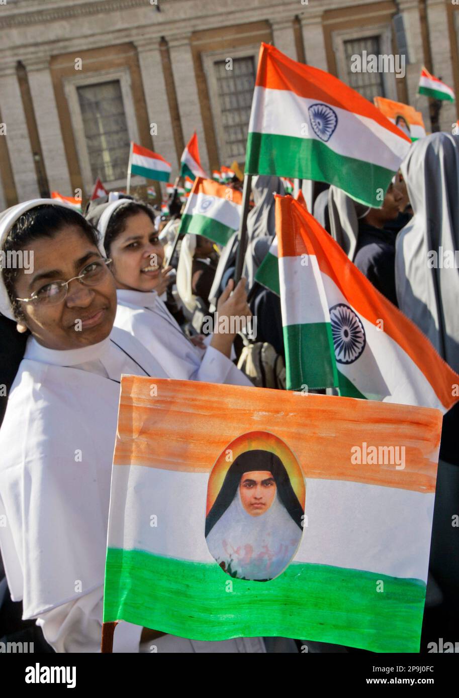 Indian nuns wave flags and a banner depicting Sister Alphonsa of the ...