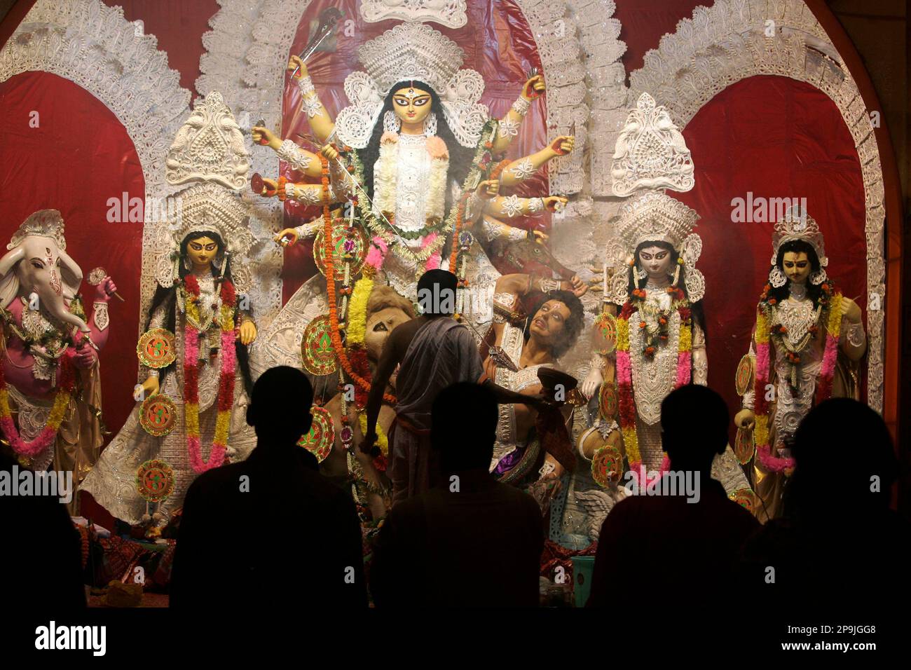 Devotees worship idols of Hindu goddess Durga, center, and other ...