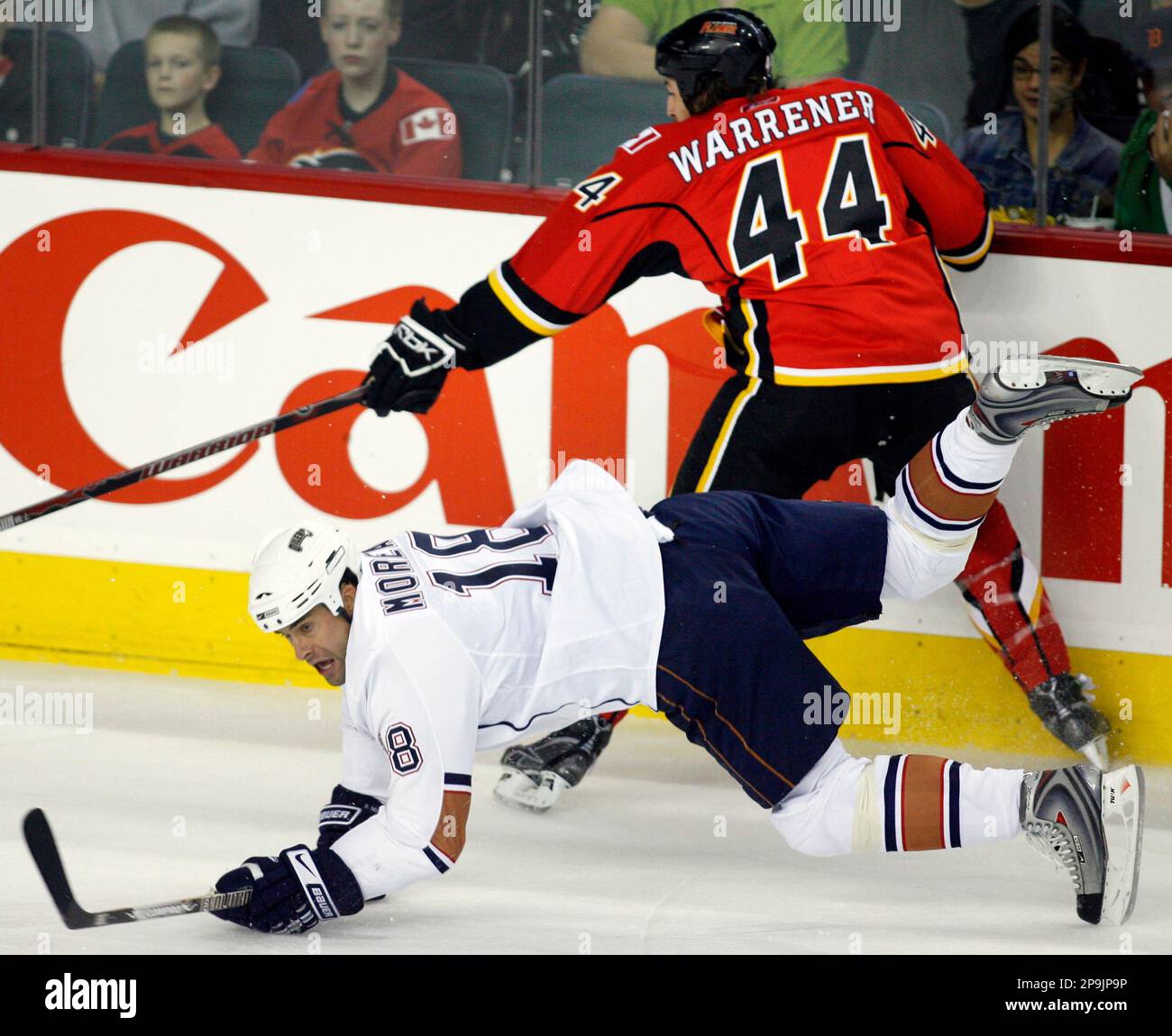 Edmonton Oilers' Ethan Moreau, left, falls to the ice after a hit from ...