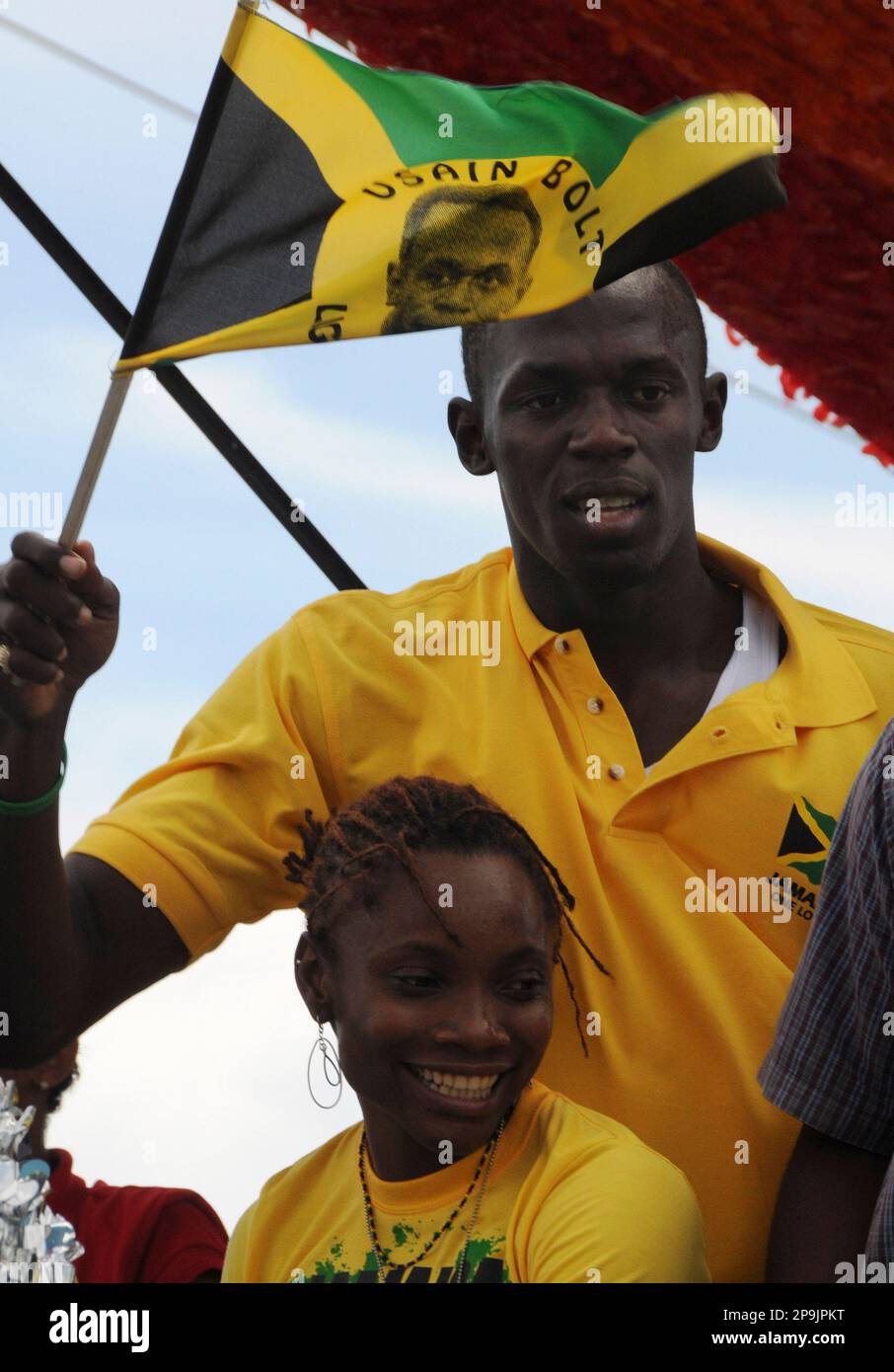 Olympic champion Usain Bolt, rear, waves a Jamaican flag, accompanied ...