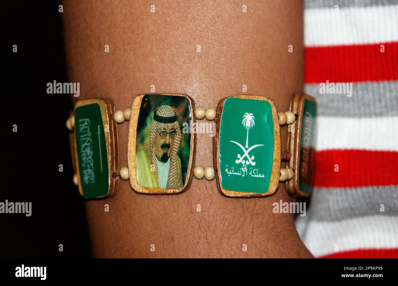 A Saudi young wears a band with a portrait of King Abdullah bin Abdul ...