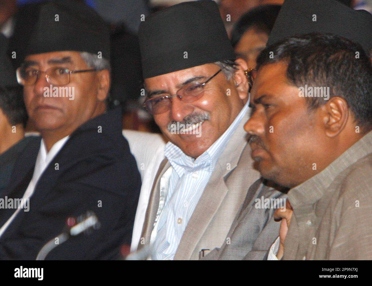 Nepal's Prime Minister Puspa Kamal Dahal Prachanda, center, smiles as former Prime Minister Sher ...