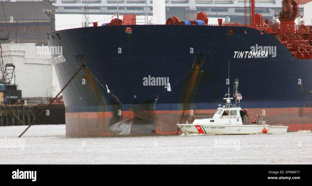 A Coast Guard boat passes the tanker Tintomara that is anchored in the ...